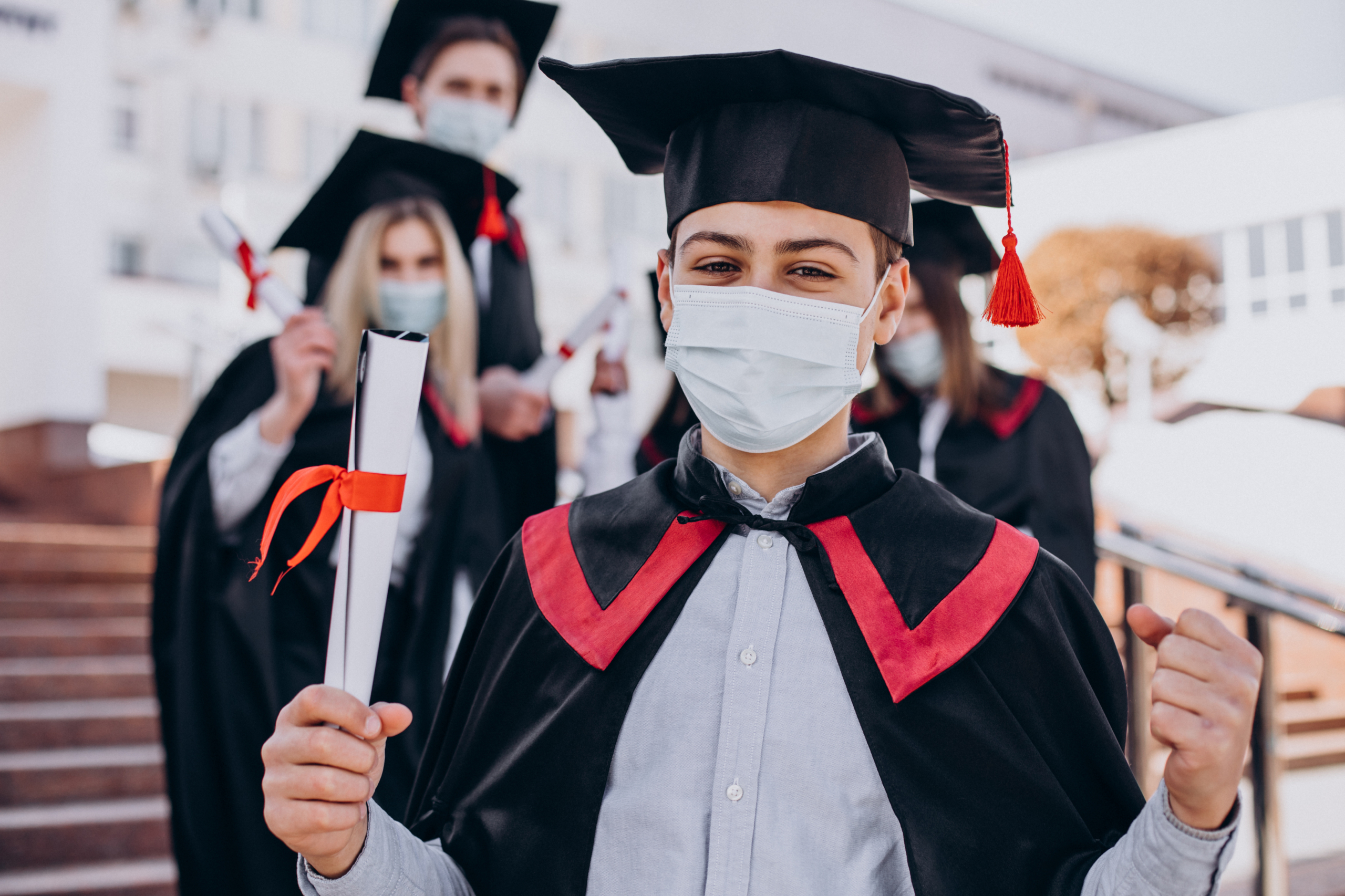 Group of students celebrating graduation together and wearing face ...